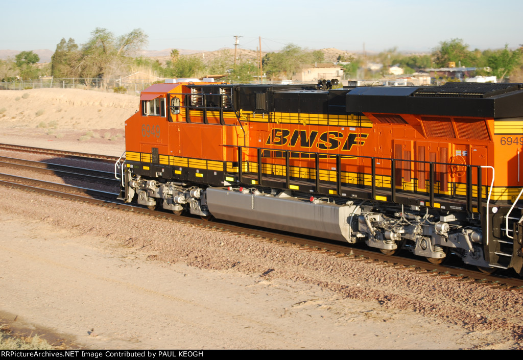 BNSF 6949 heads west as she passes me with the Sun Gleeming off Her Very Brand New Swoosh Logo ...